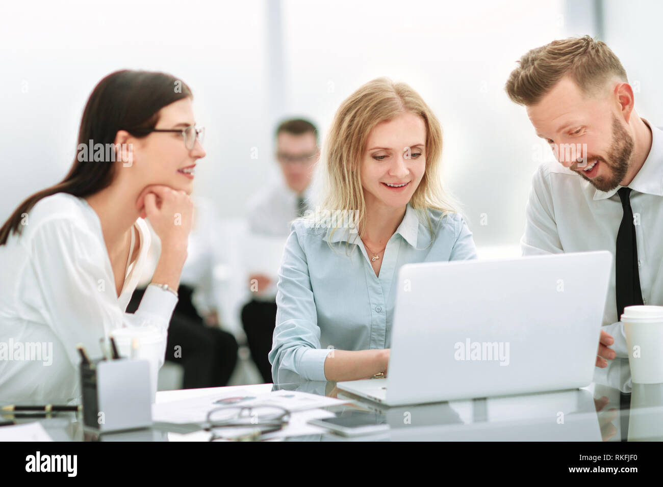 smiling employees sitting at the office Desk Stock Photo - Alamy