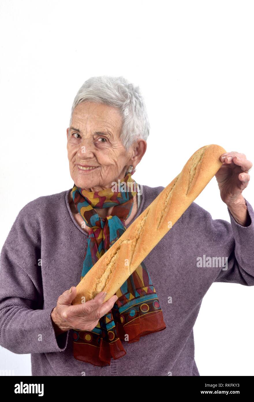 senior woman eating bread on white background Stock Photo - Alamy