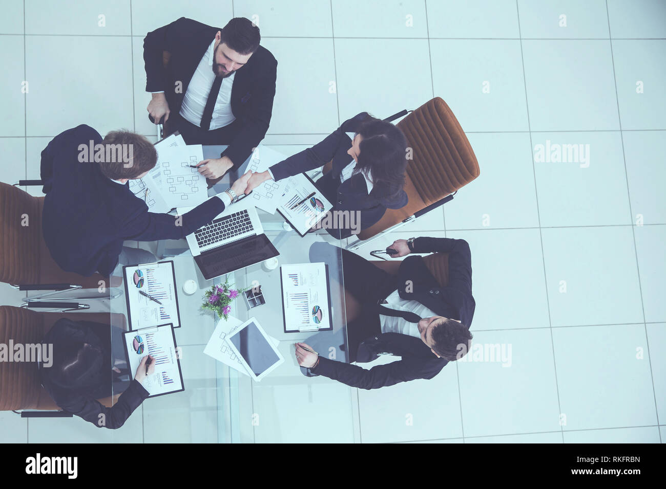 business partners shaking hands after a discussion of the new fiscal ...