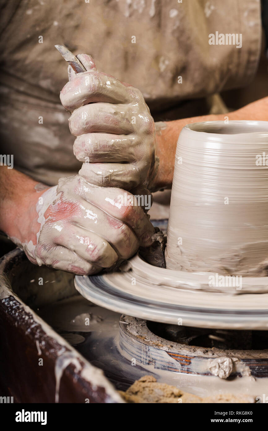the process of creating a pottery on a twisted Potter's wheel. Dirty ...