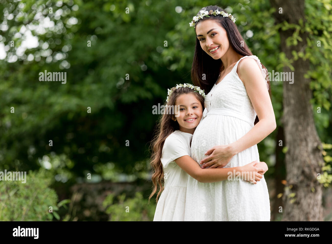 Happy kid girl hugging pregnant mother hi-res stock photography and ...