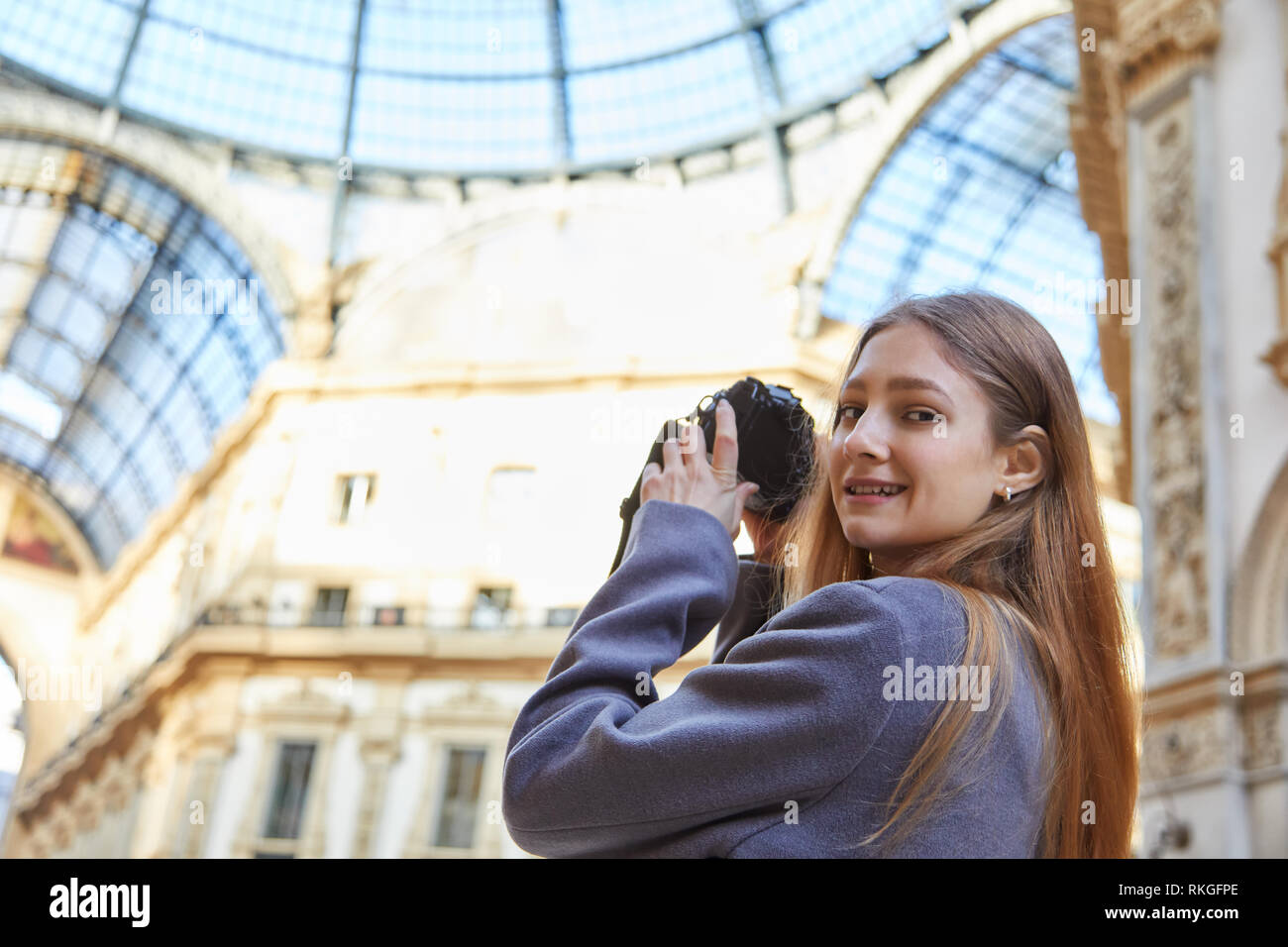 Tourist girl smile and takes a photo in Galleria Vittorio Emanuele II ...