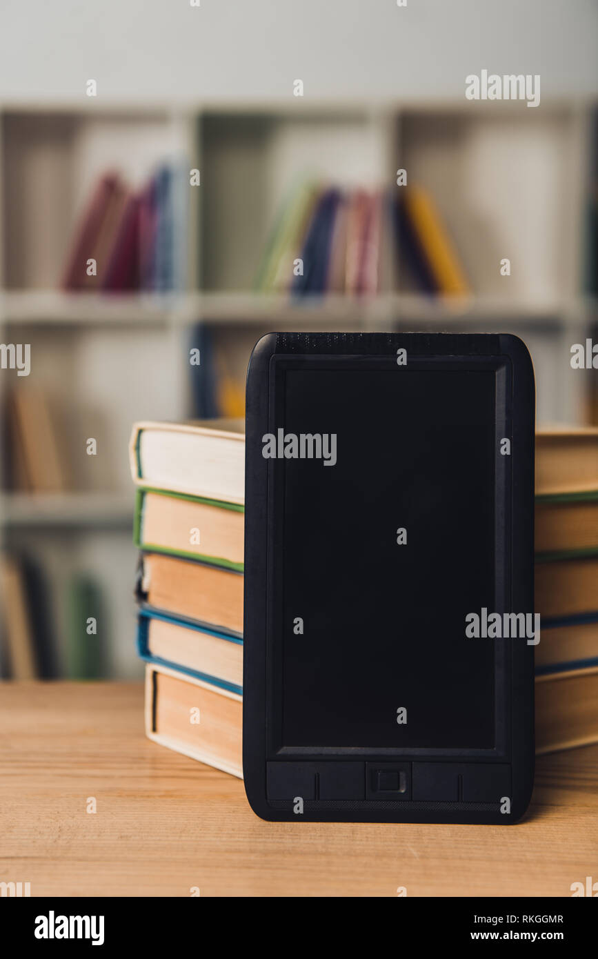 ebook with blank screen near paper books on table Stock Photo - Alamy