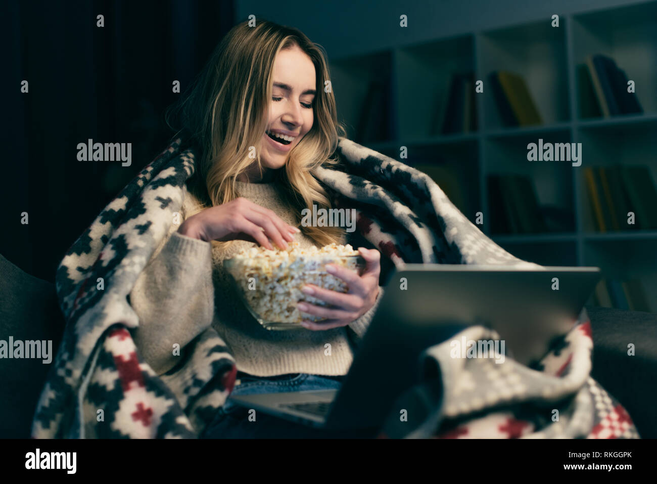 happy watching movie on laptop and holding bowl with popcorn Stock ...