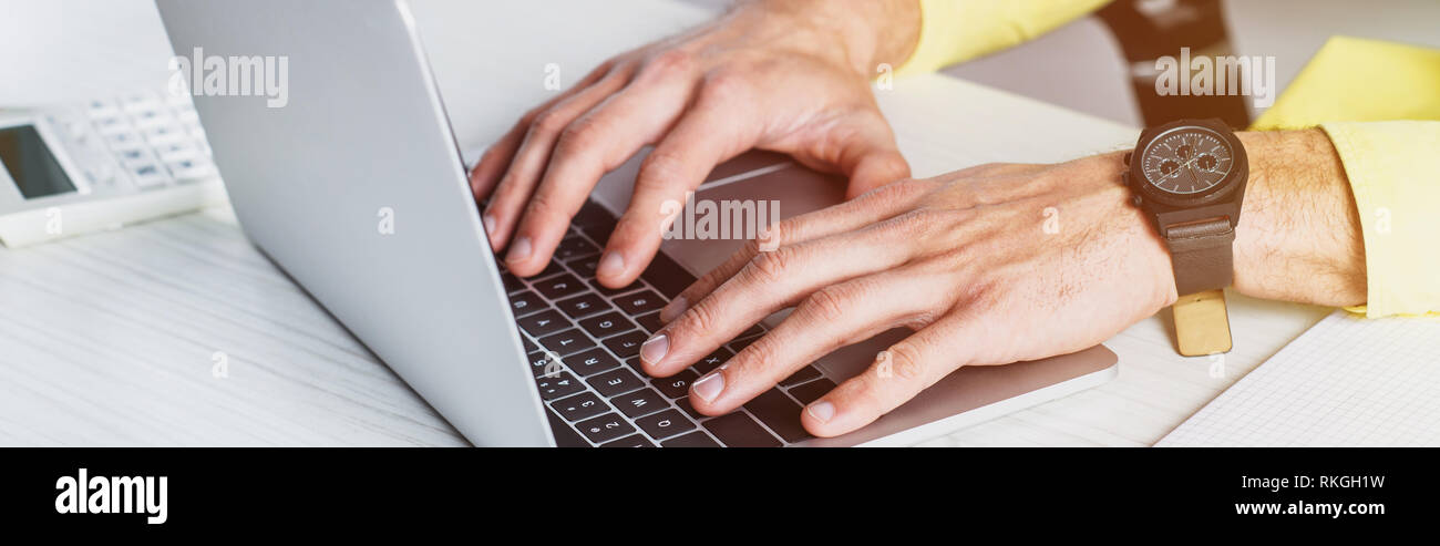 Partial view of man typing on laptop keyboard Stock Photo - Alamy