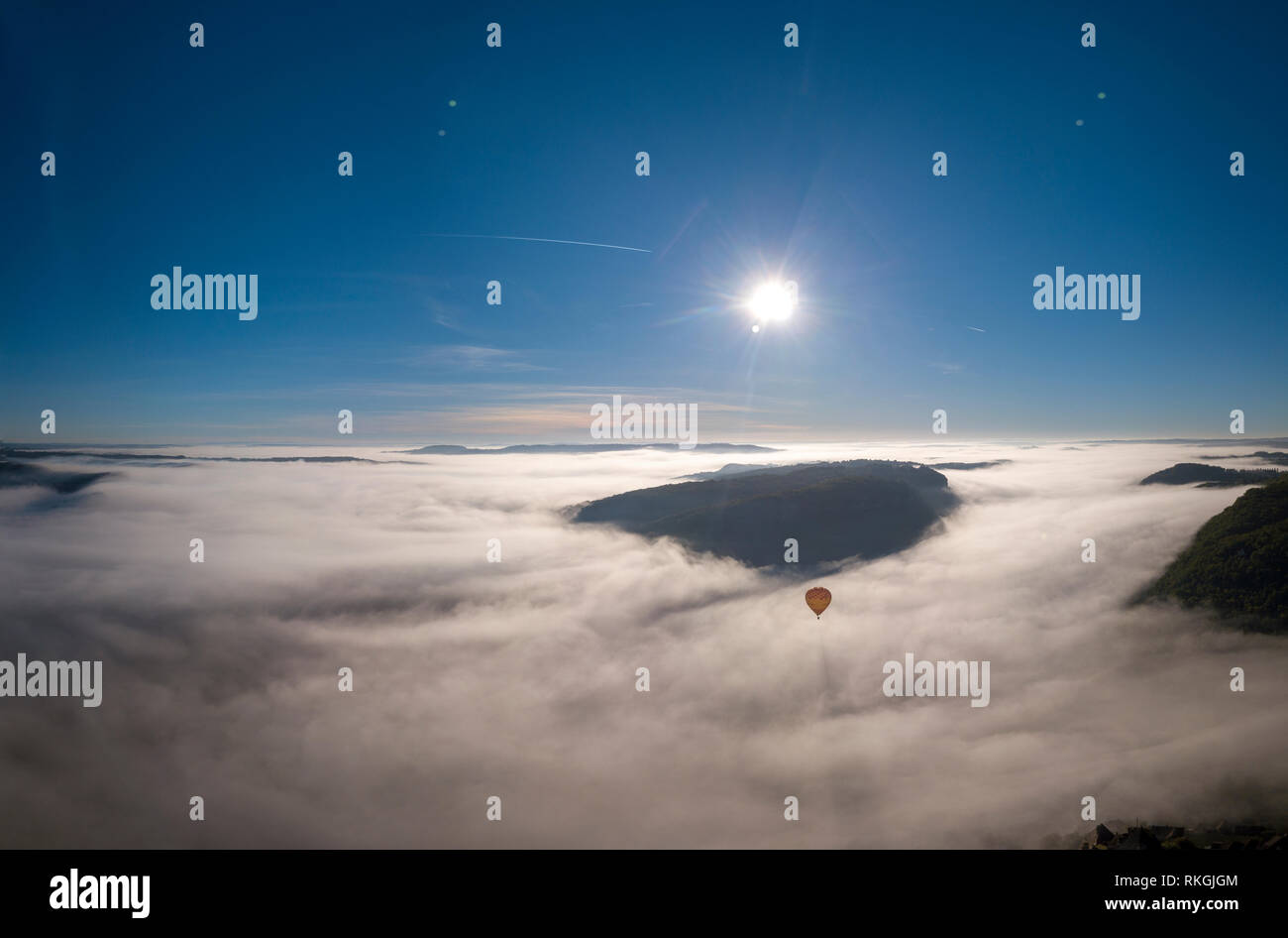 Hot air balloon flying over fog near Beynac Chateau, Dordogne ...