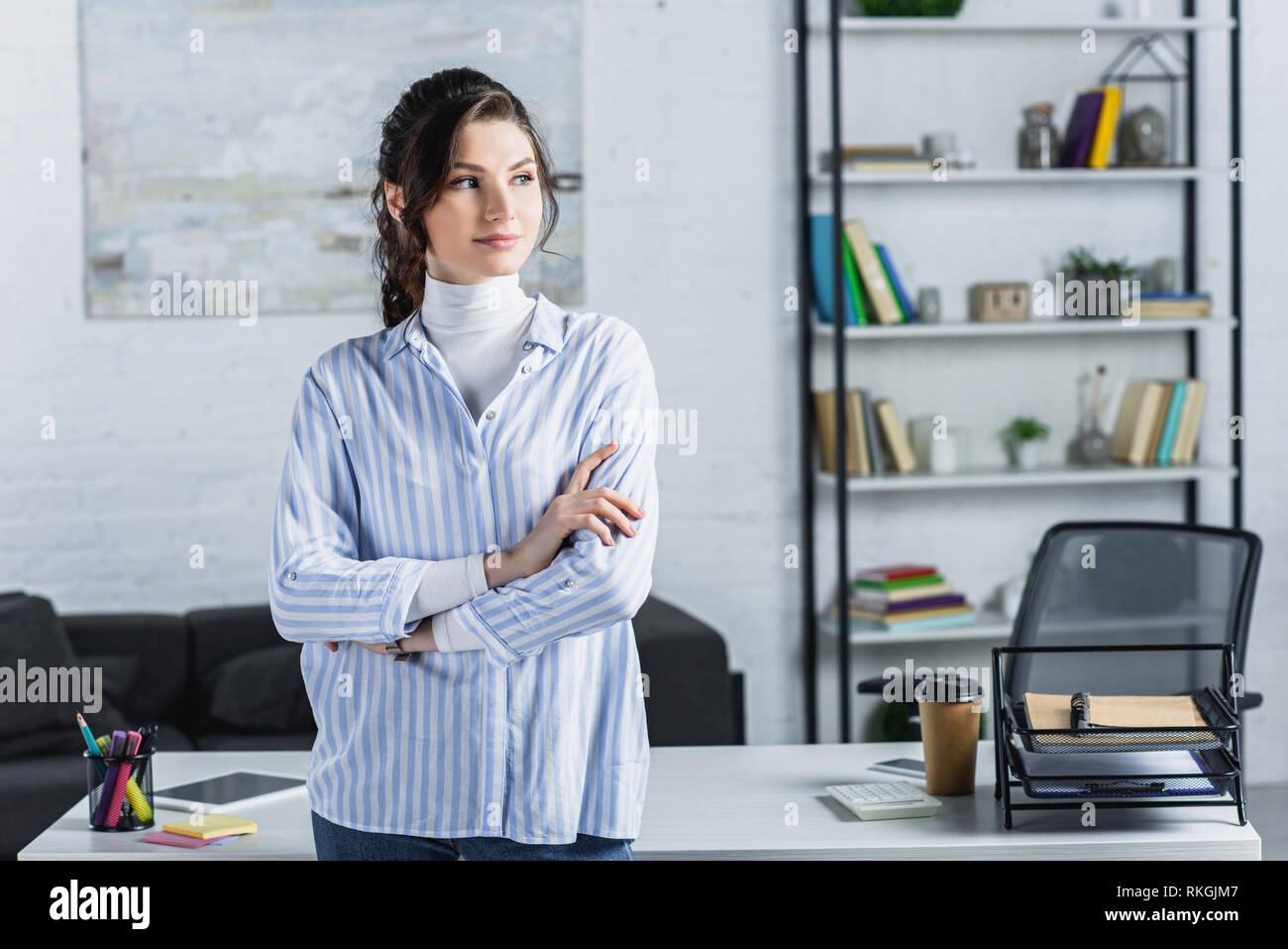beautiful woman standing with crossed arms in modern office Stock Photo ...