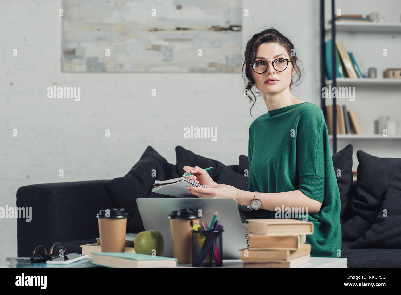 thoughtful woman in glasses writing in notebook at home Stock Photo - Alamy