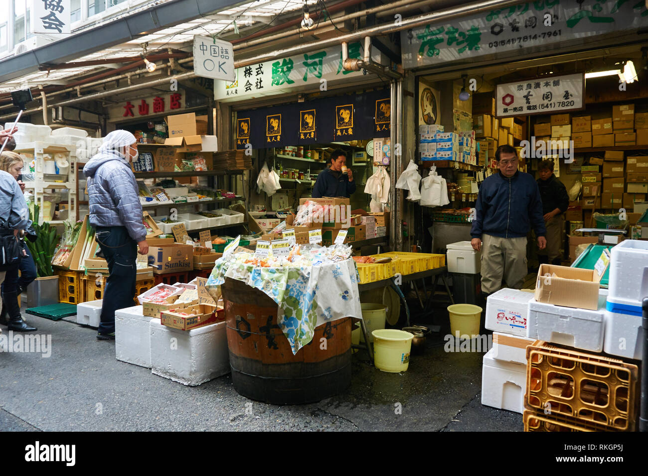 Merchants and customers stand in shops Tsukiji fish market's outer ...