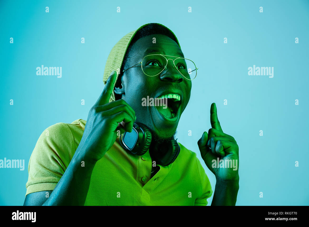 The young handsome happy surprised hipster man listening music with ...