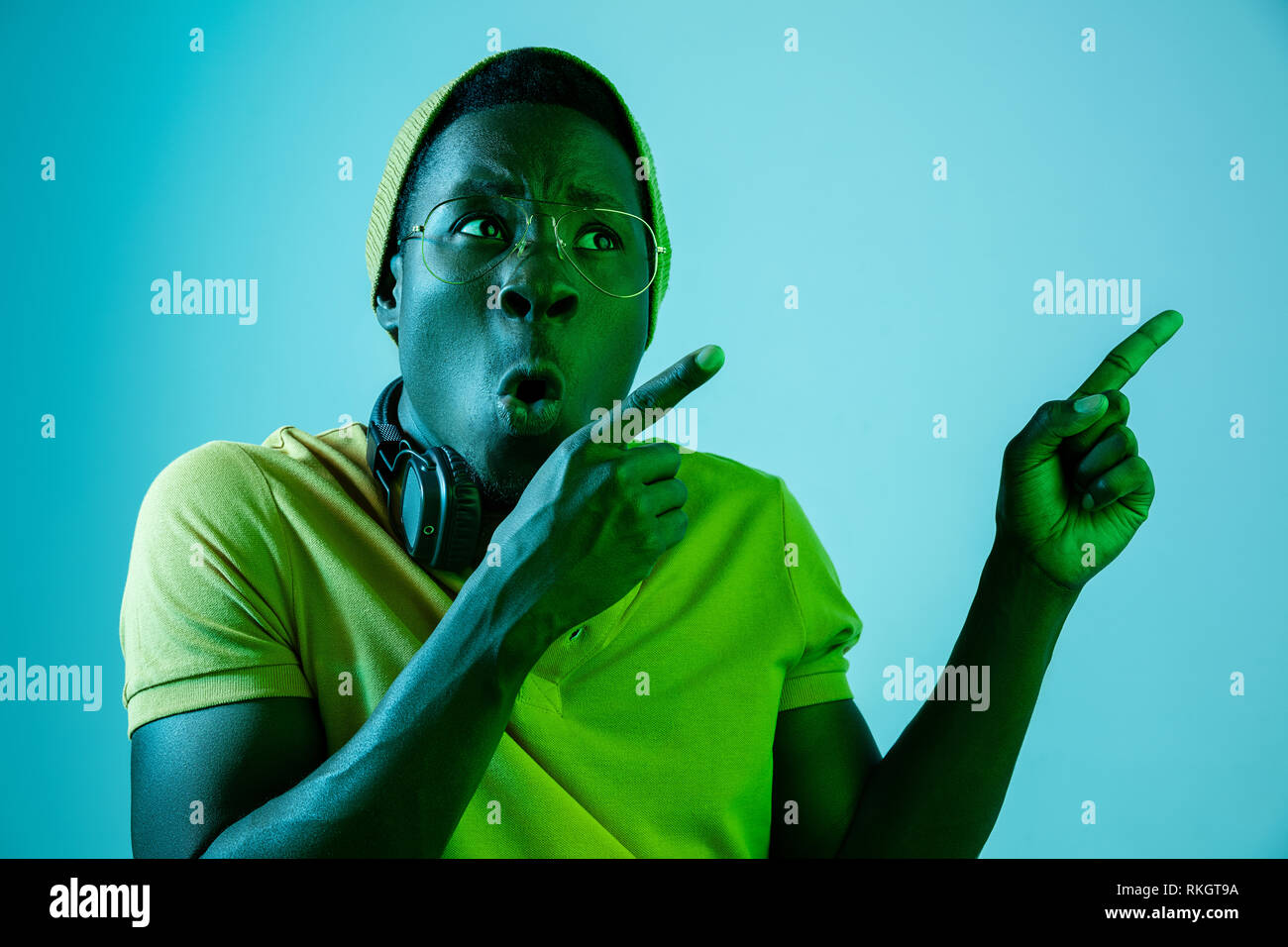 The young handsome happy surprised hipster man listening music with ...