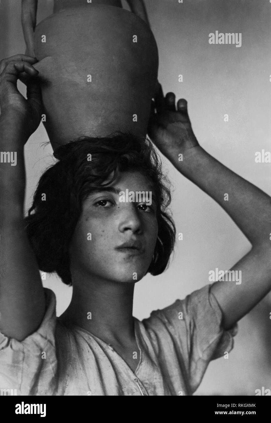 Woman carrying jar with her head Black and White Stock Photos & Images ...