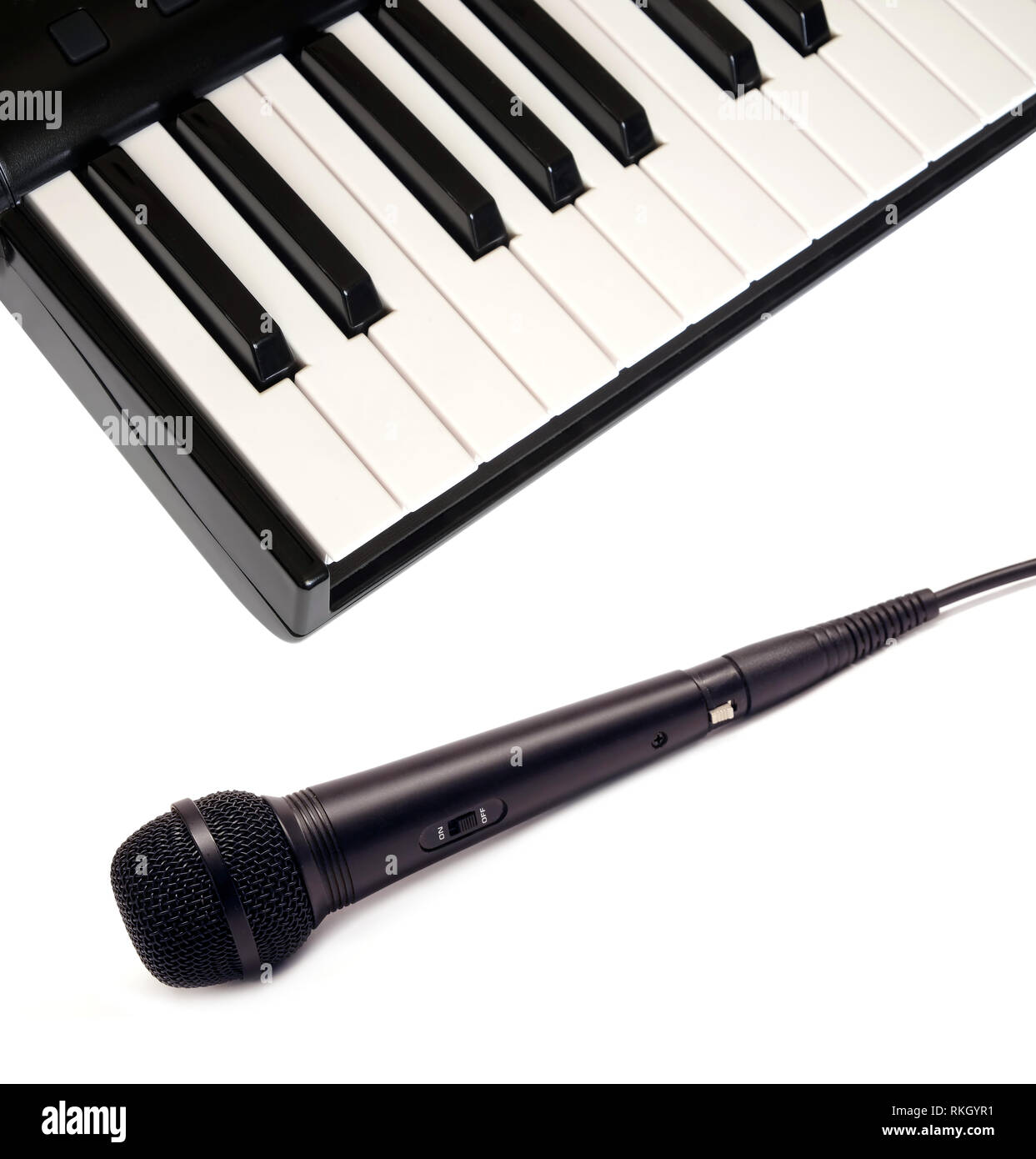 Piano keyboard with white and black keys and vocal microphone isolated ...