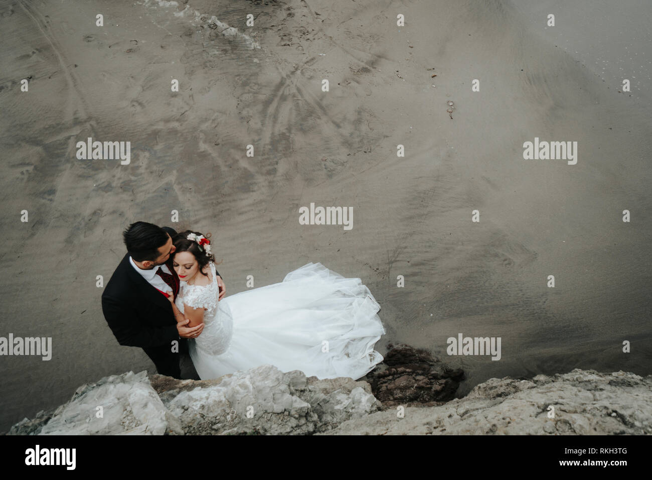 Charming wedding couple hugging on the beach. View from above. The ...