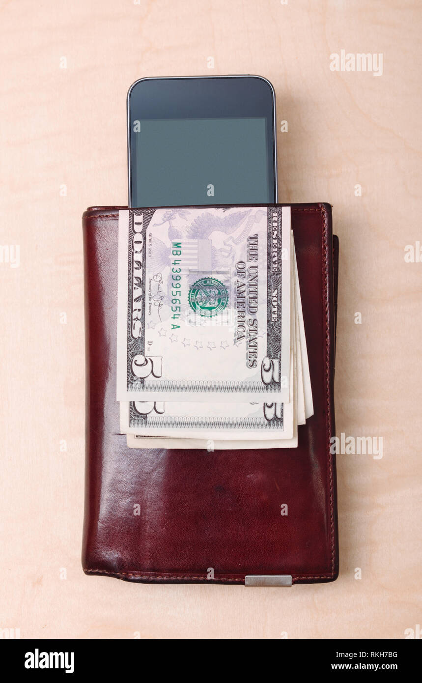 Wallet, smartphone with blank screen and dollar banknotes on wooden ...