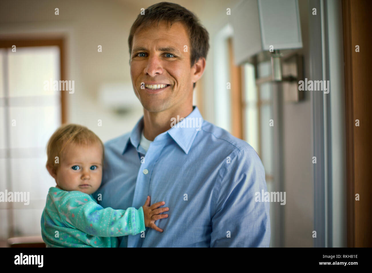 Portrait of a smiling father holding his baby daughter Stock Photo - Alamy