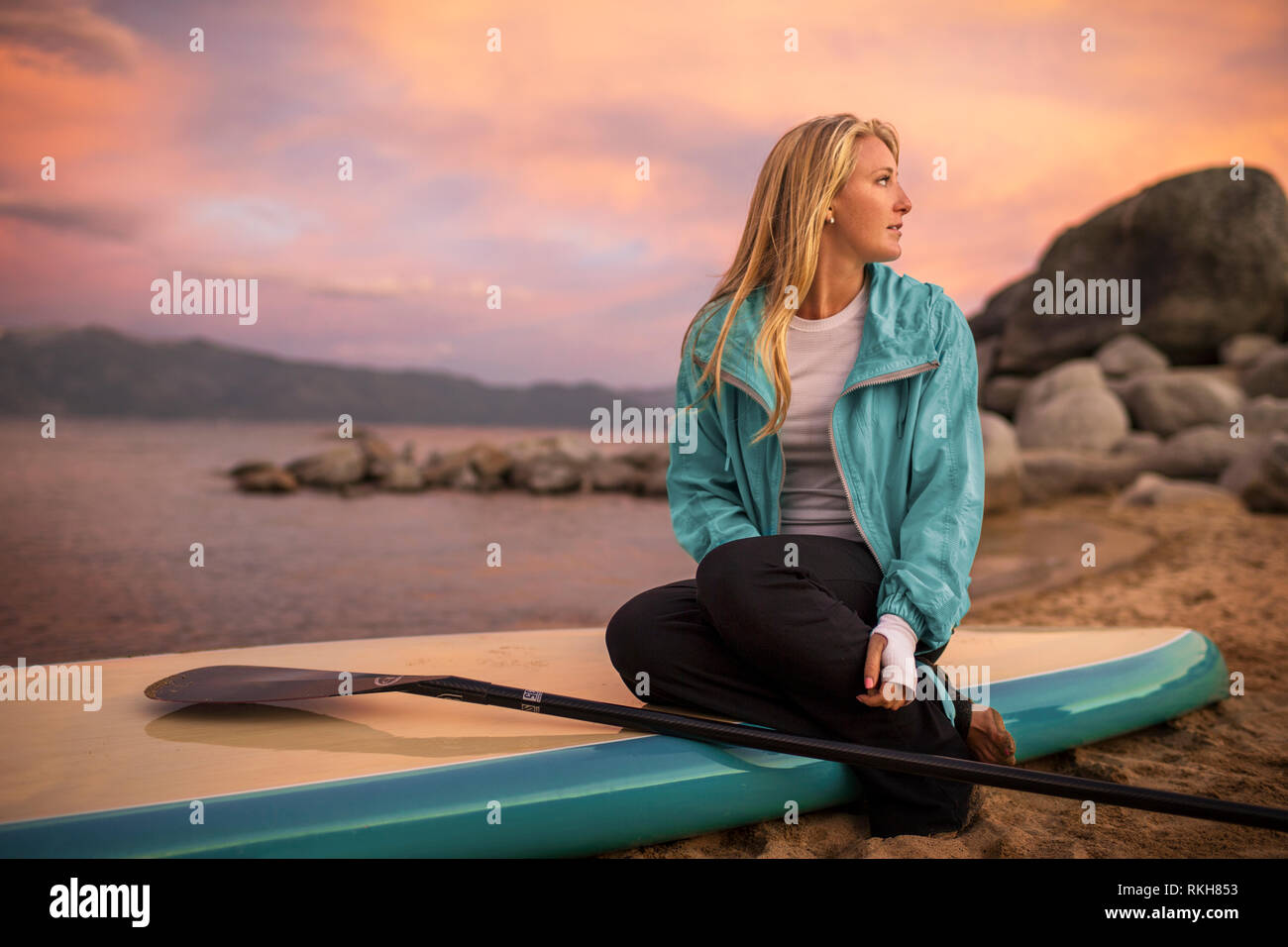 Young woman sitting on her paddleboard Stock Photo - Alamy