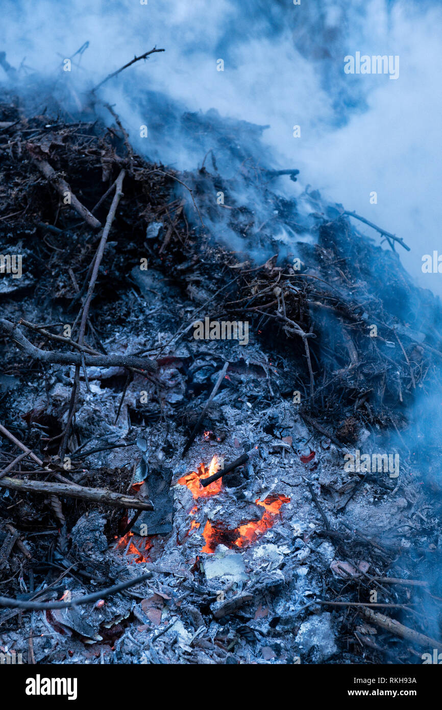 Glowing embers and smoke from a dying bonfire Stock Photo - Alamy