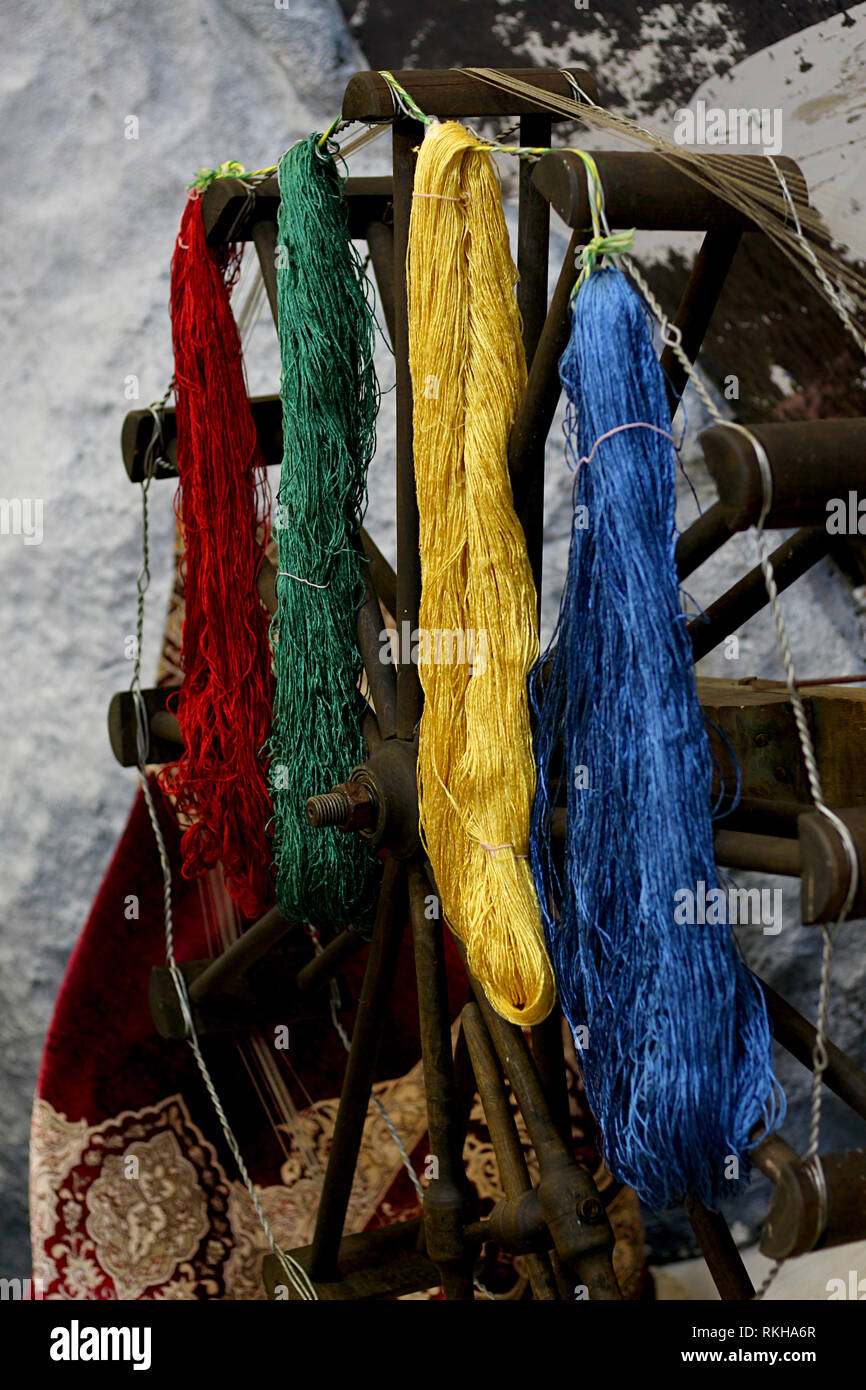 Yarns hanging from spinning machine to red blue green and yellow Stock ...