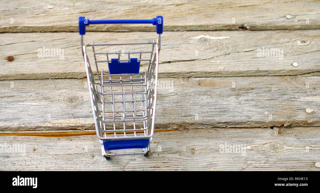 small shopping cart on a wood background, image of a Stock Photo - Alamy