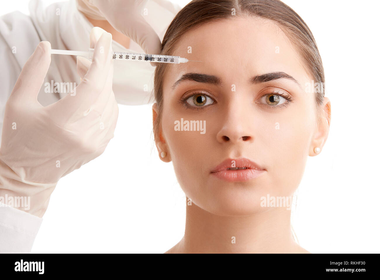 Portrait of an attractive young woman receiving botox treatment ...