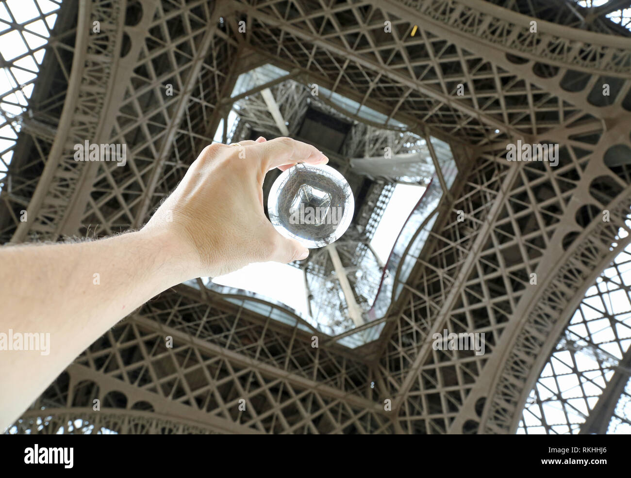 hand with the crystal ball under the Eiffel tower in Paris in France ...