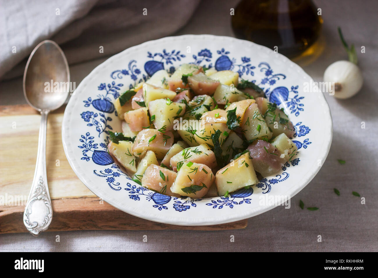 Traditional cold potato salad with onions and herbs on a linen ...