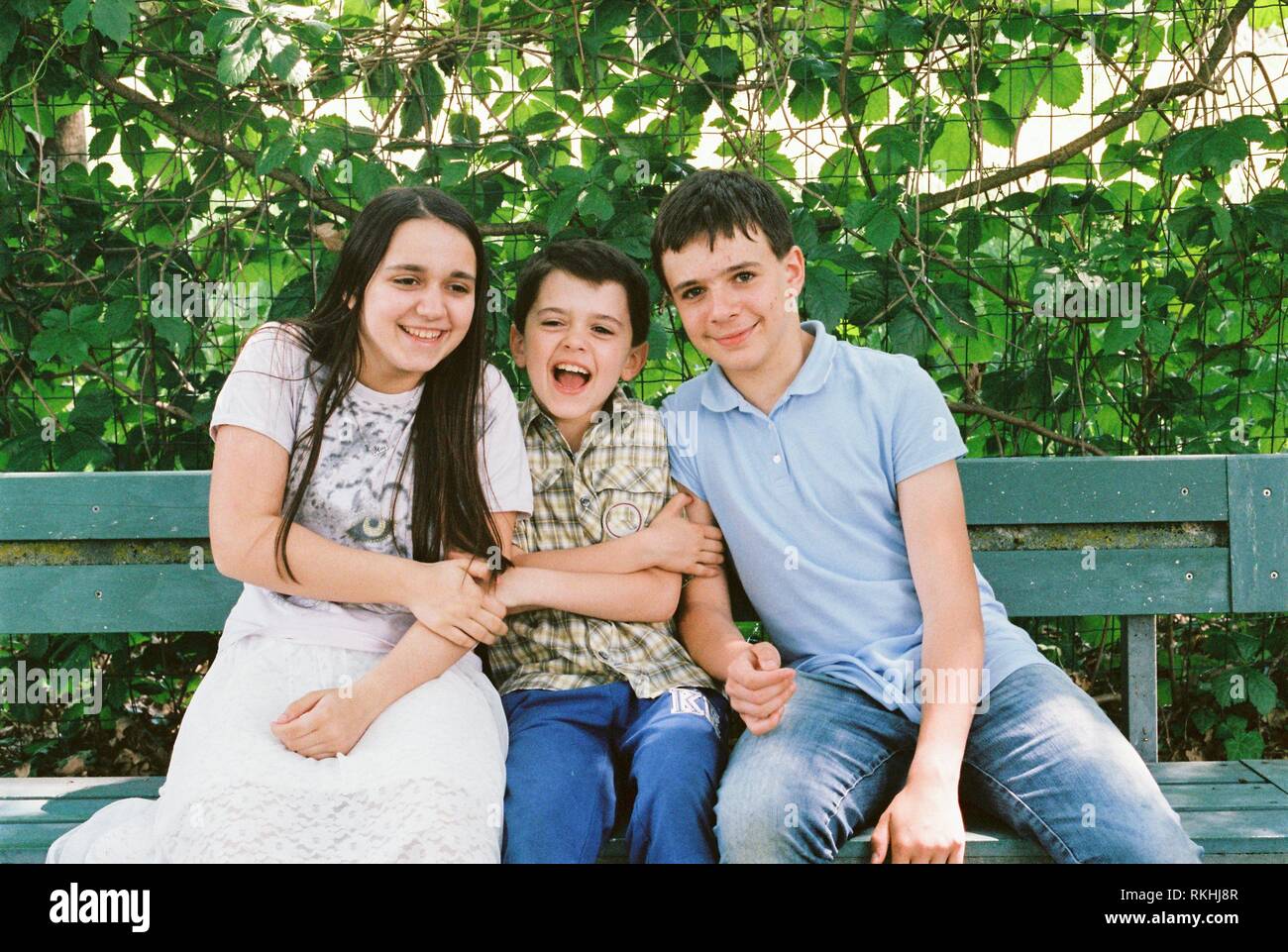 portrait of brothers children sitting on a bench two brothers and a ...