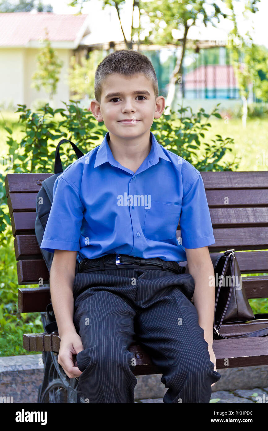 Cute boy are sitting on the bench in summer Stock Photo - Alamy