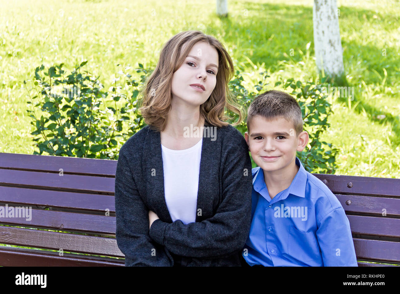 Brother and sister are sitting on bench in summer Stock Photo - Alamy