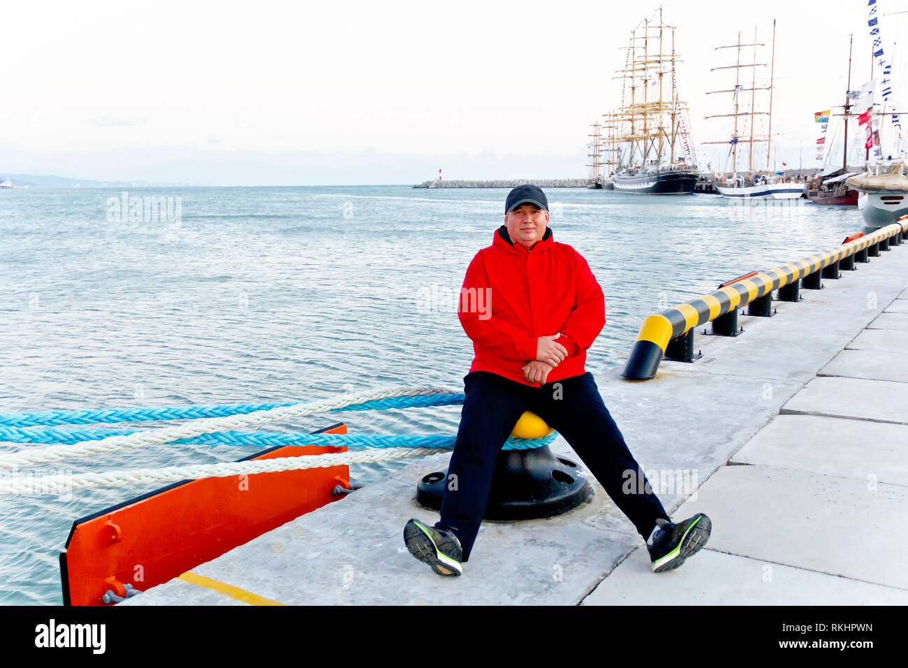 Big fat man in red jacket on ship and sea background Stock Photo - Alamy