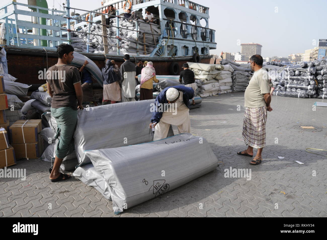 A group of Asian dock workers (dockers) preparing goods for export to ...