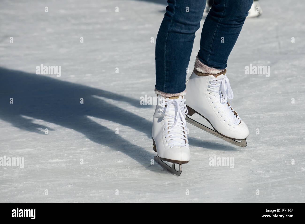 Female legs in ice skates at ice-skating rink Stock Photo - Alamy