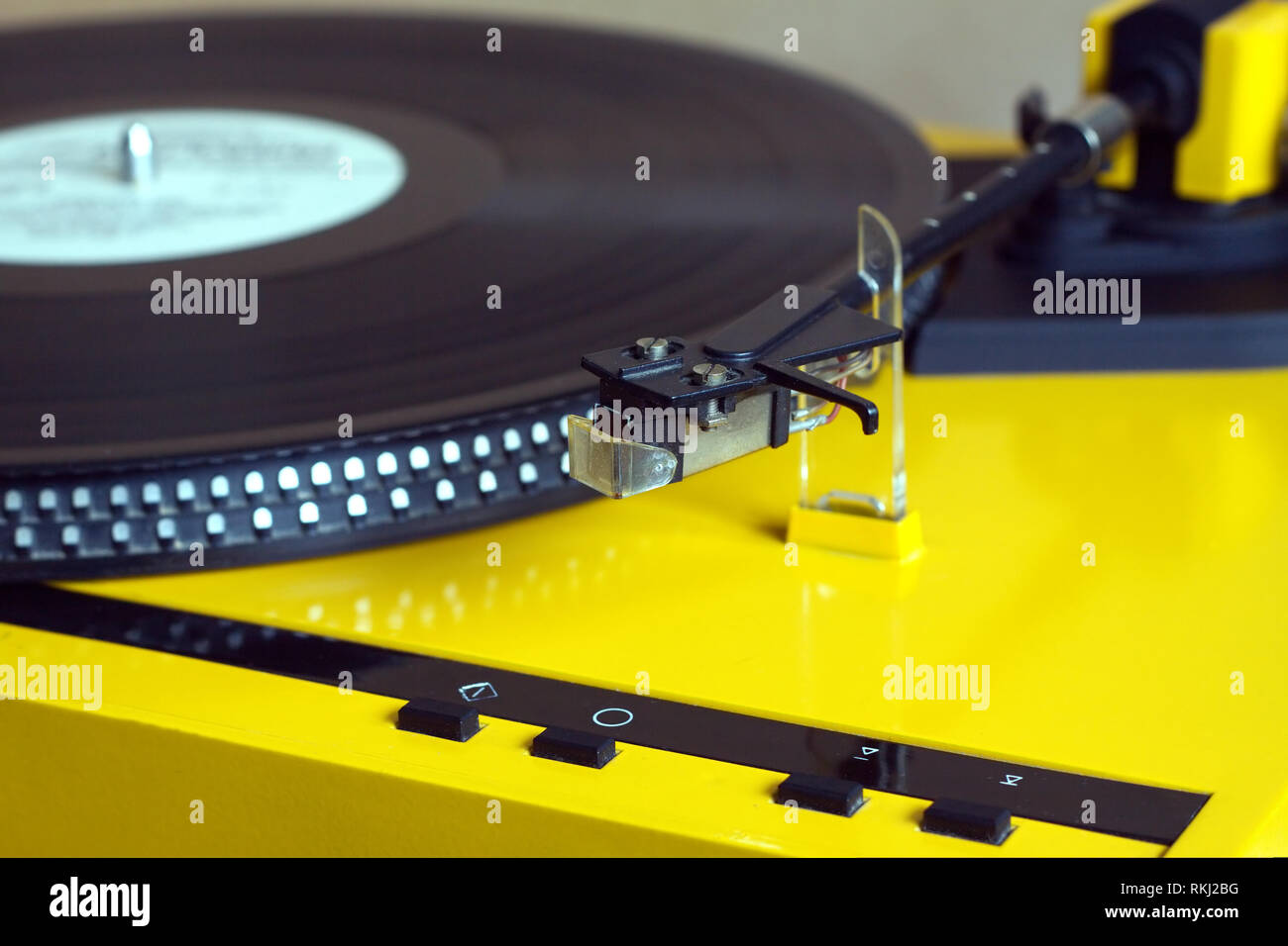 Turntable in yellow case playing a vinyl record with white label ...