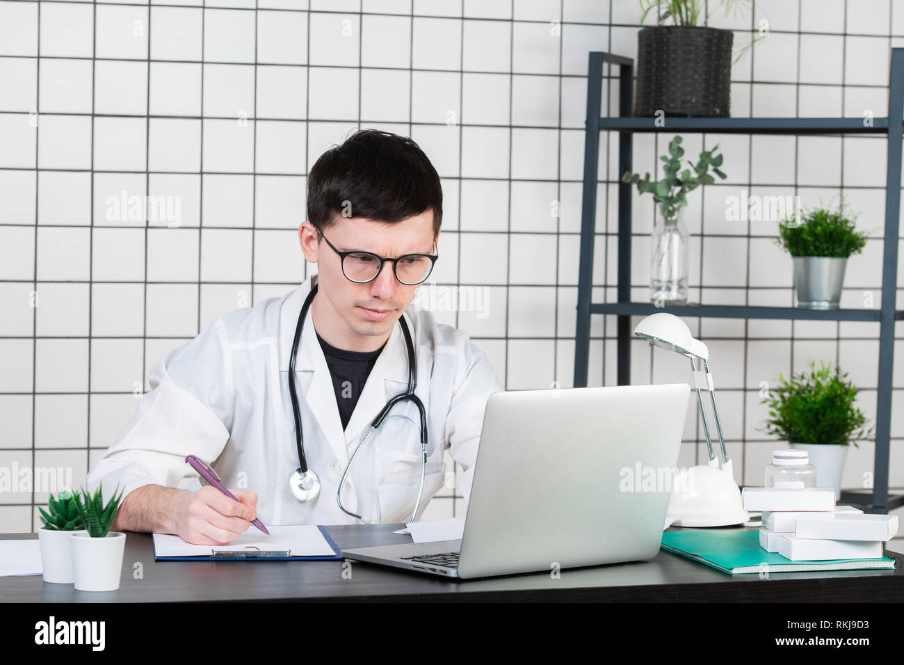 Doctor stethoscope holding laptop typing hi-res stock photography and ...