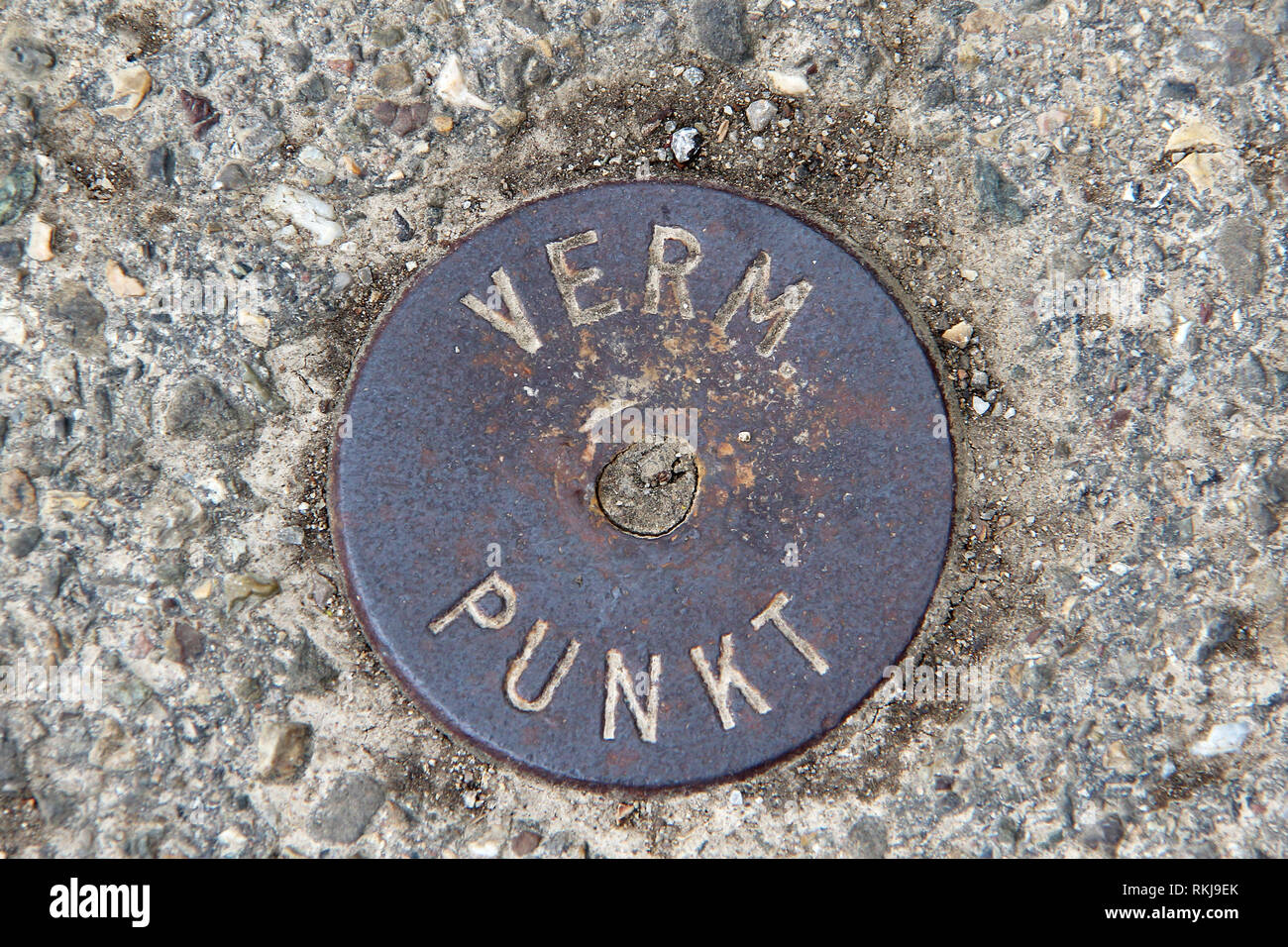 Vermessungspunkt -surveying point. A survey point is mounted on asphalt ...