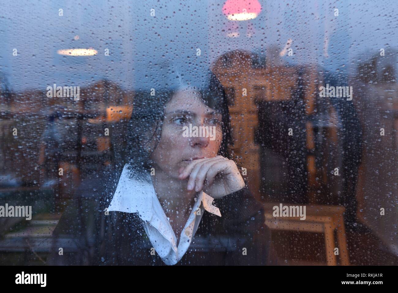 Woman looking out rainy window hi-res stock photography and images - Alamy