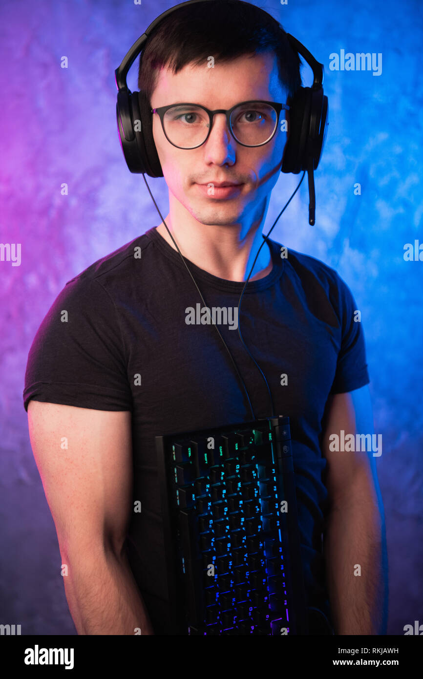 Professional Boy Gamer holding gaming keyboard over colorful pink and ...