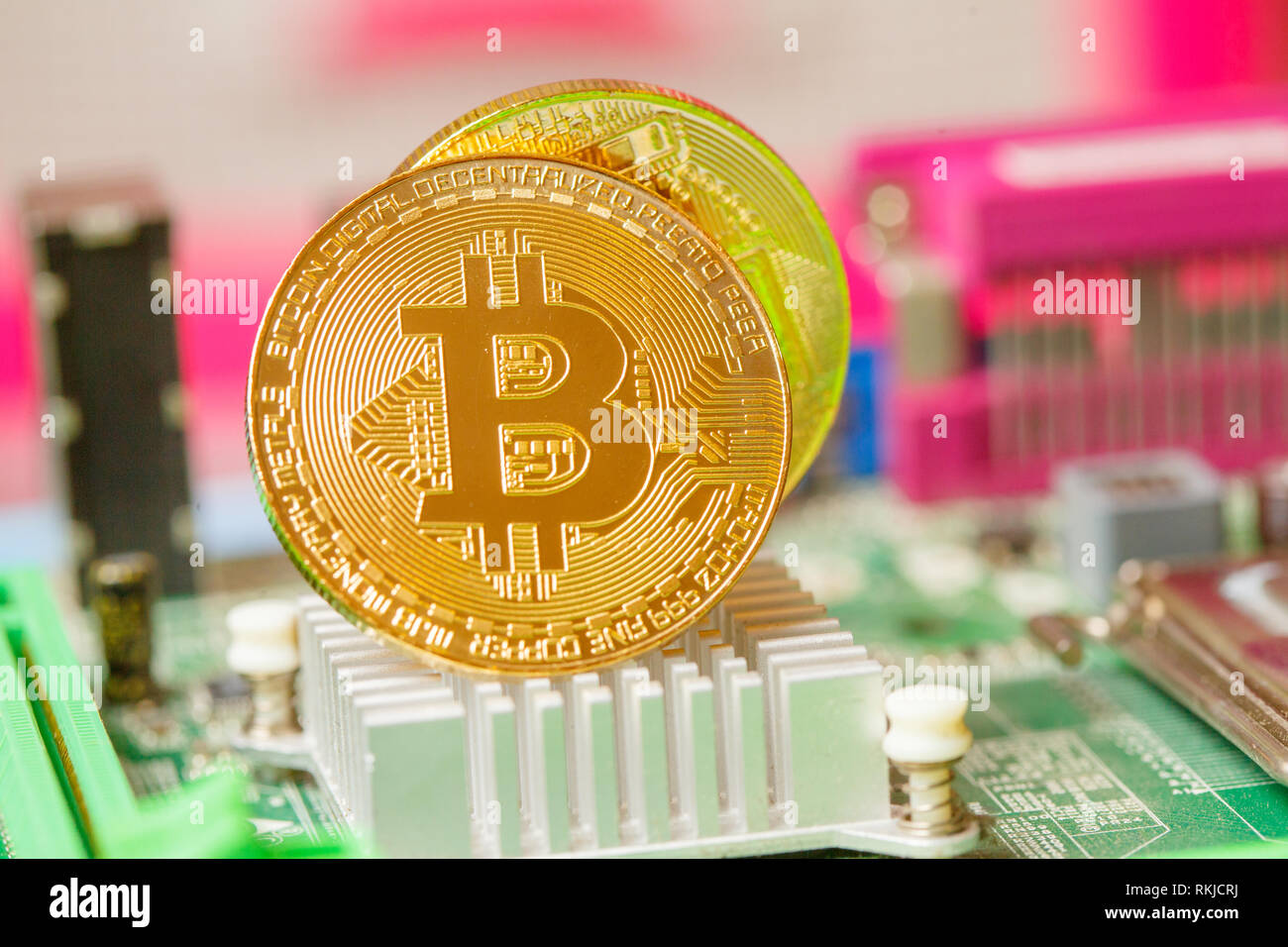 Gold Bitcoin coin with motherboard computer circuit board.Electronic ...