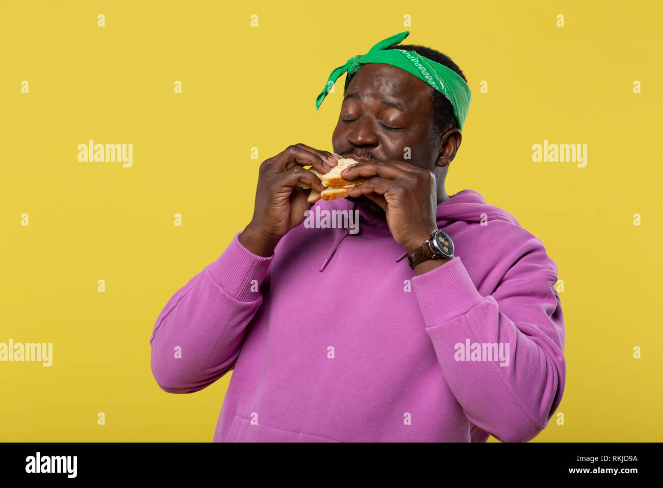 Delighted male person eating with closed eyes Stock Photo - Alamy