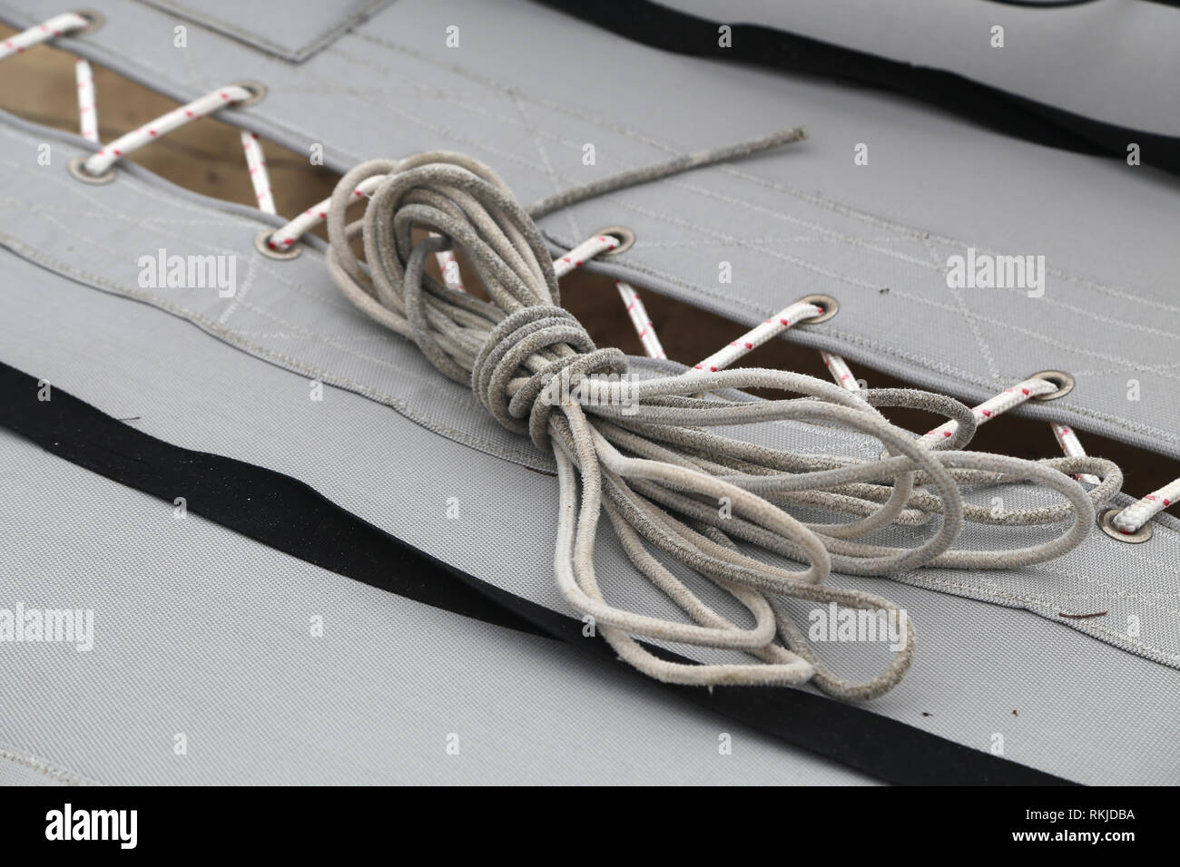 Rope-bound tarpaulin on a catamaran Stock Photo - Alamy