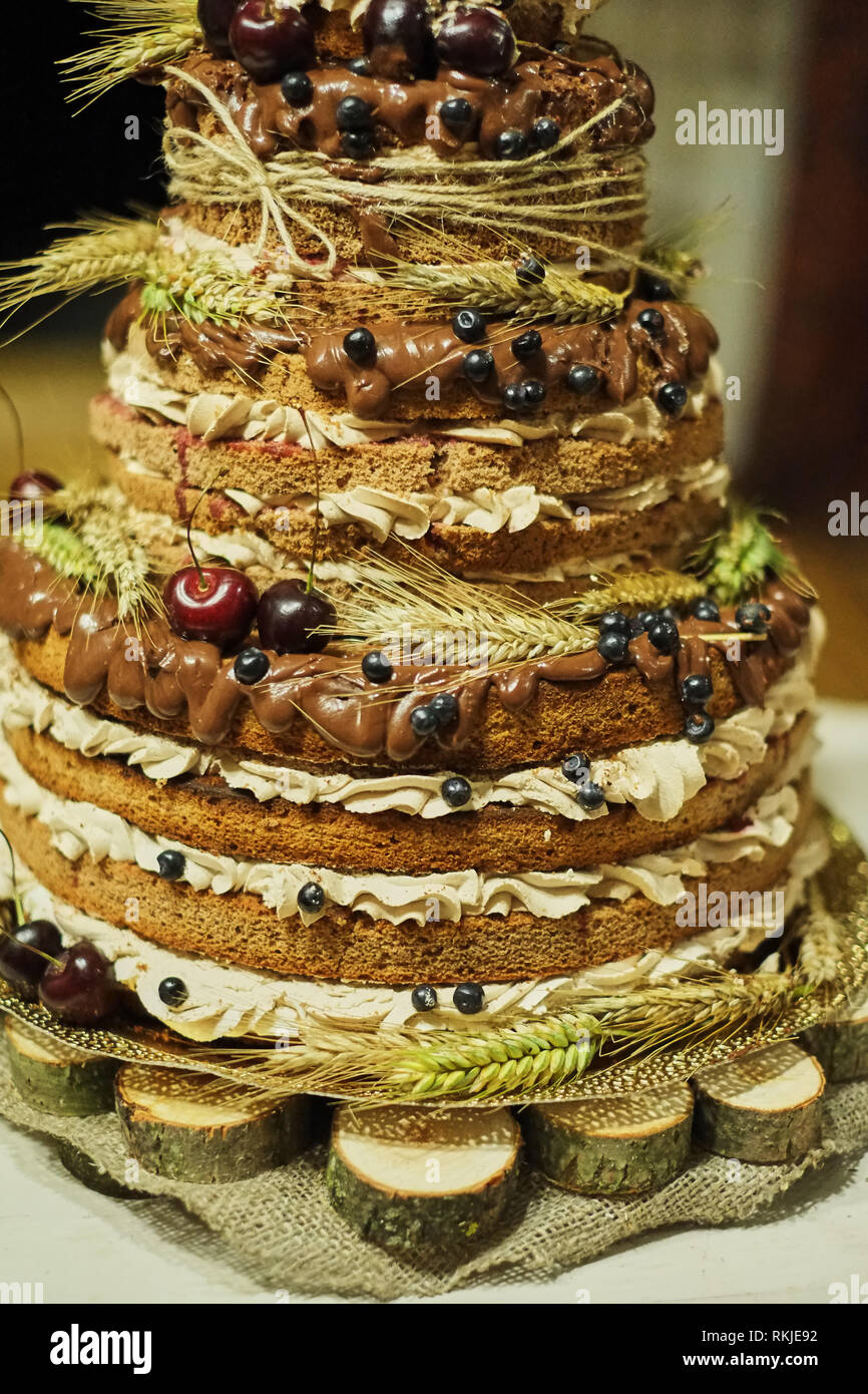 Fruit biscuit multicolor wedding cake on a large stand made of wood ...