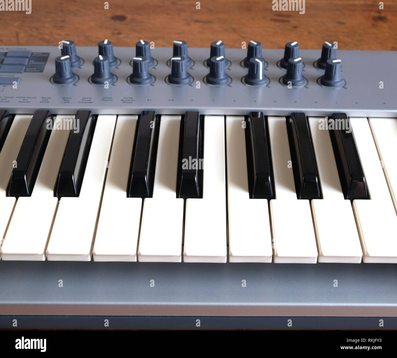 Electronic synthesizer keyboard with many control knobs in silver ...