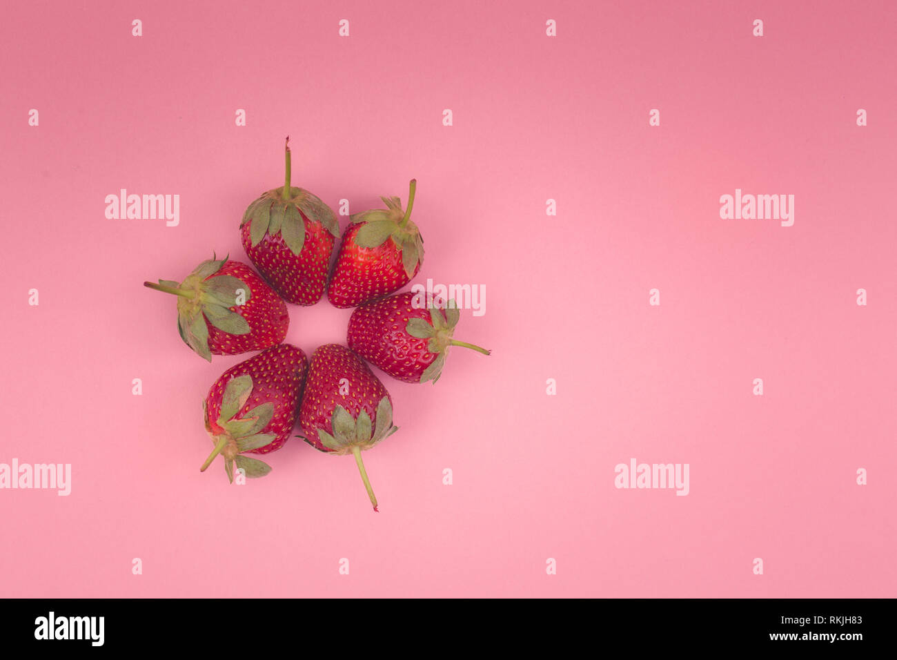 Strawberries on pink background teamwork concept Stock Photo - Alamy