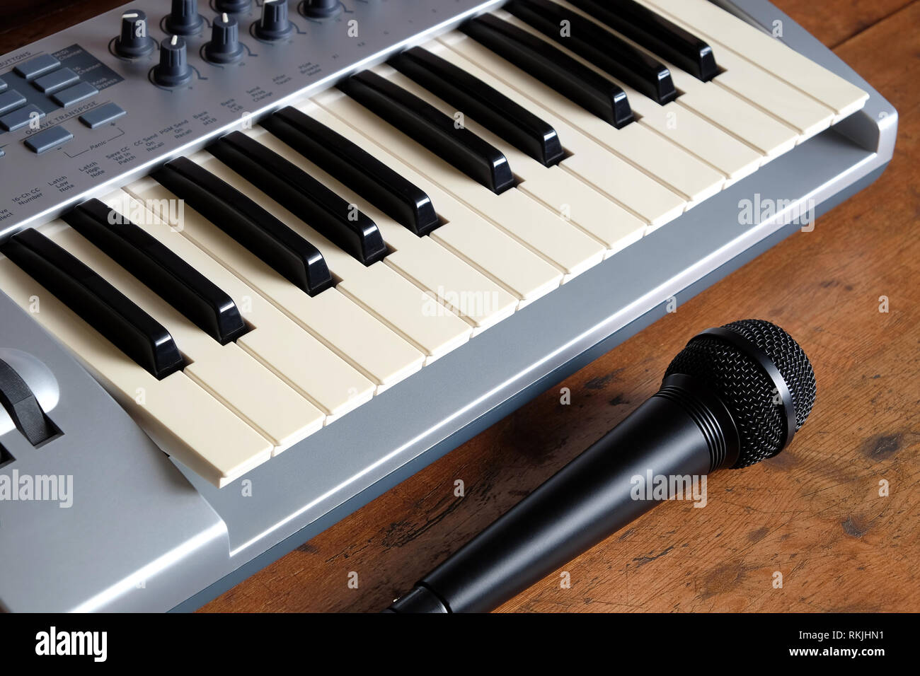 Electronic synthesizer keyboard with many control knobs in silver ...