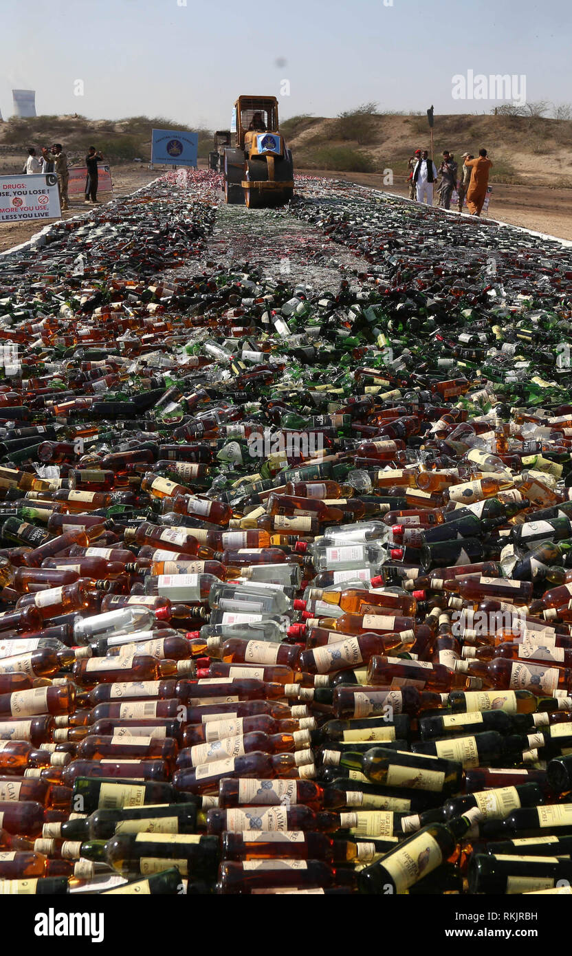 Karachi. 11th Feb, 2019. A steamroller rolls over bottles of liquor ...