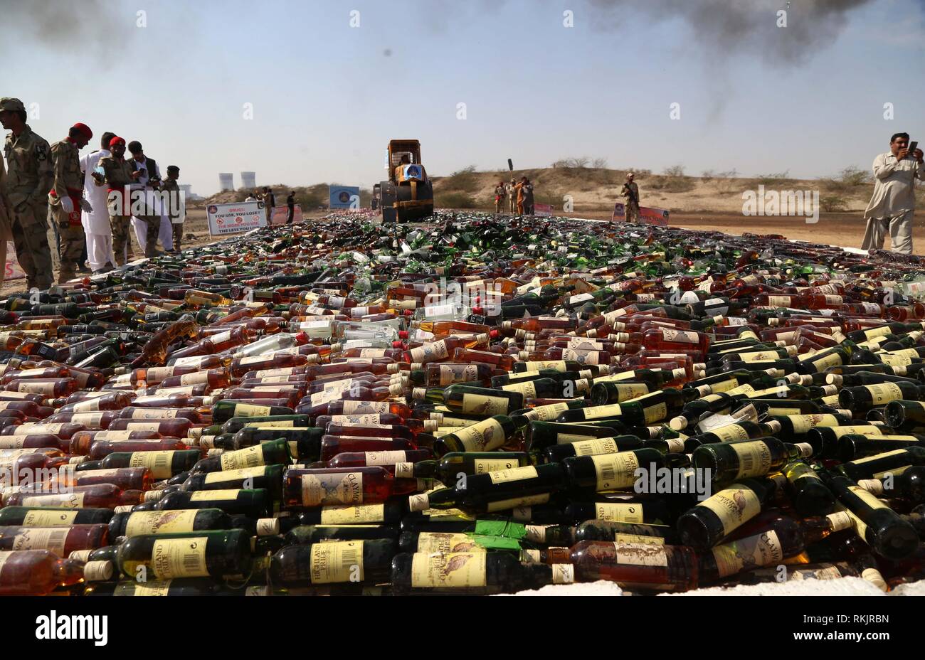 Karachi. 11th Feb, 2019. A steamroller rolls over bottles of liquor ...