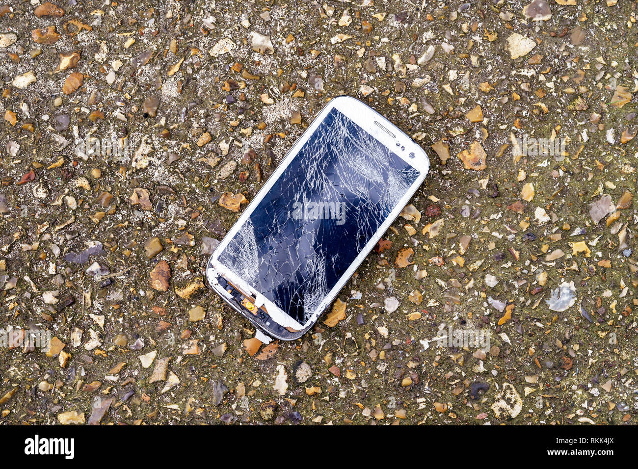 Mobile phone with smashed screen on concrete surface Stock Photo - Alamy