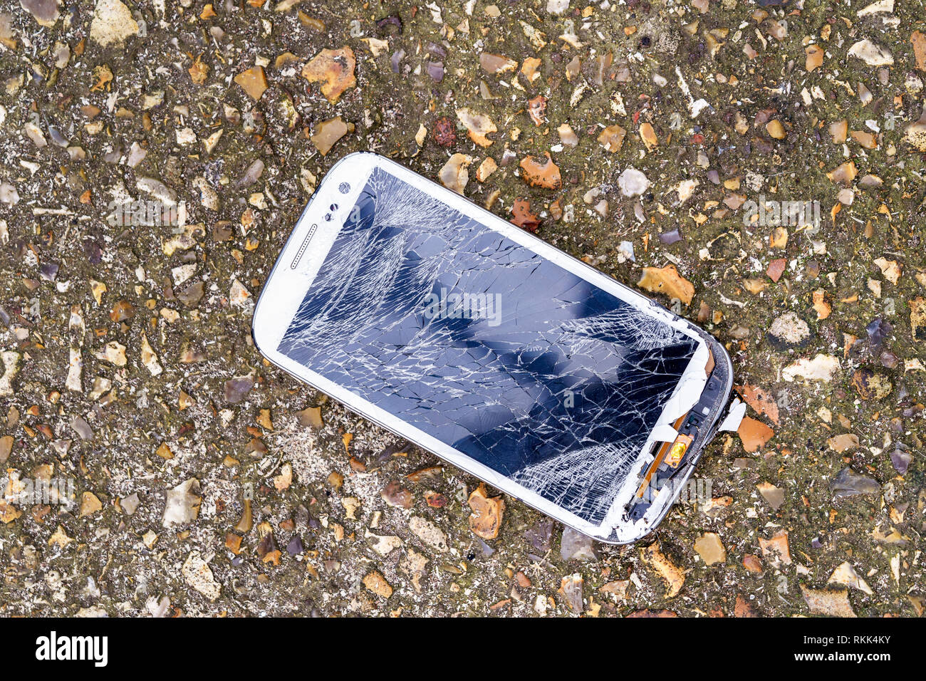 Mobile phone with smashed screen on concrete surface Stock Photo - Alamy