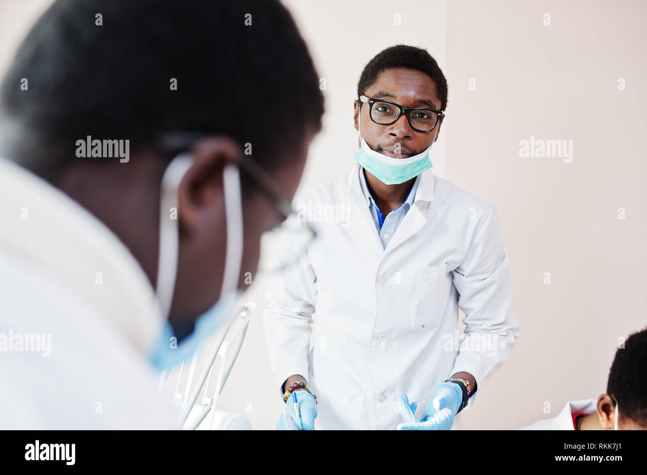 Three african american male doctors working, discussing with colleagues ...